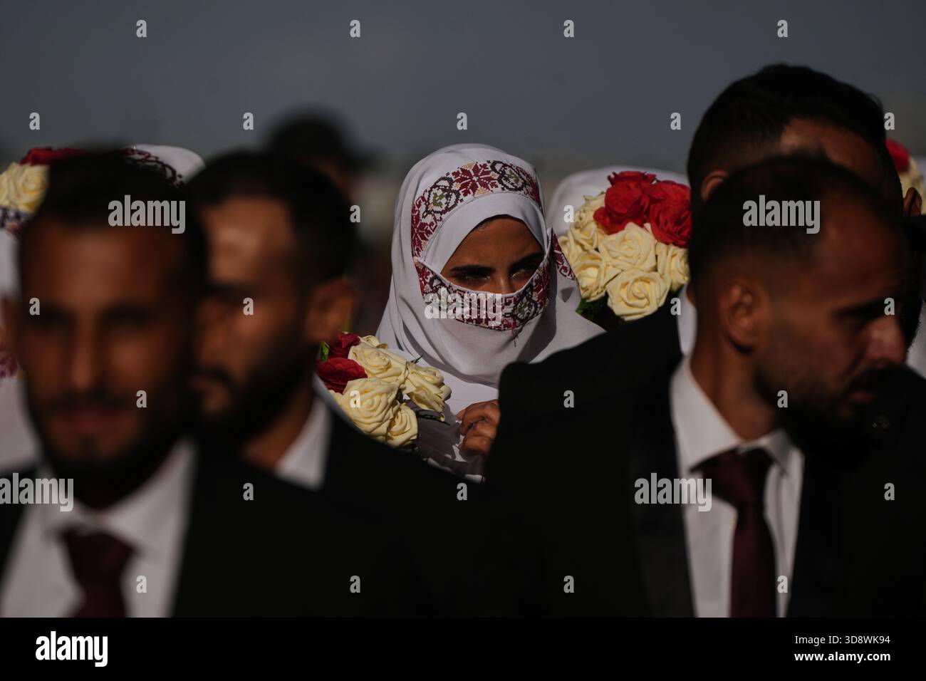 Palestinian couples participate in a mass wedding ceremony at Hamad City in Khan Younis ...