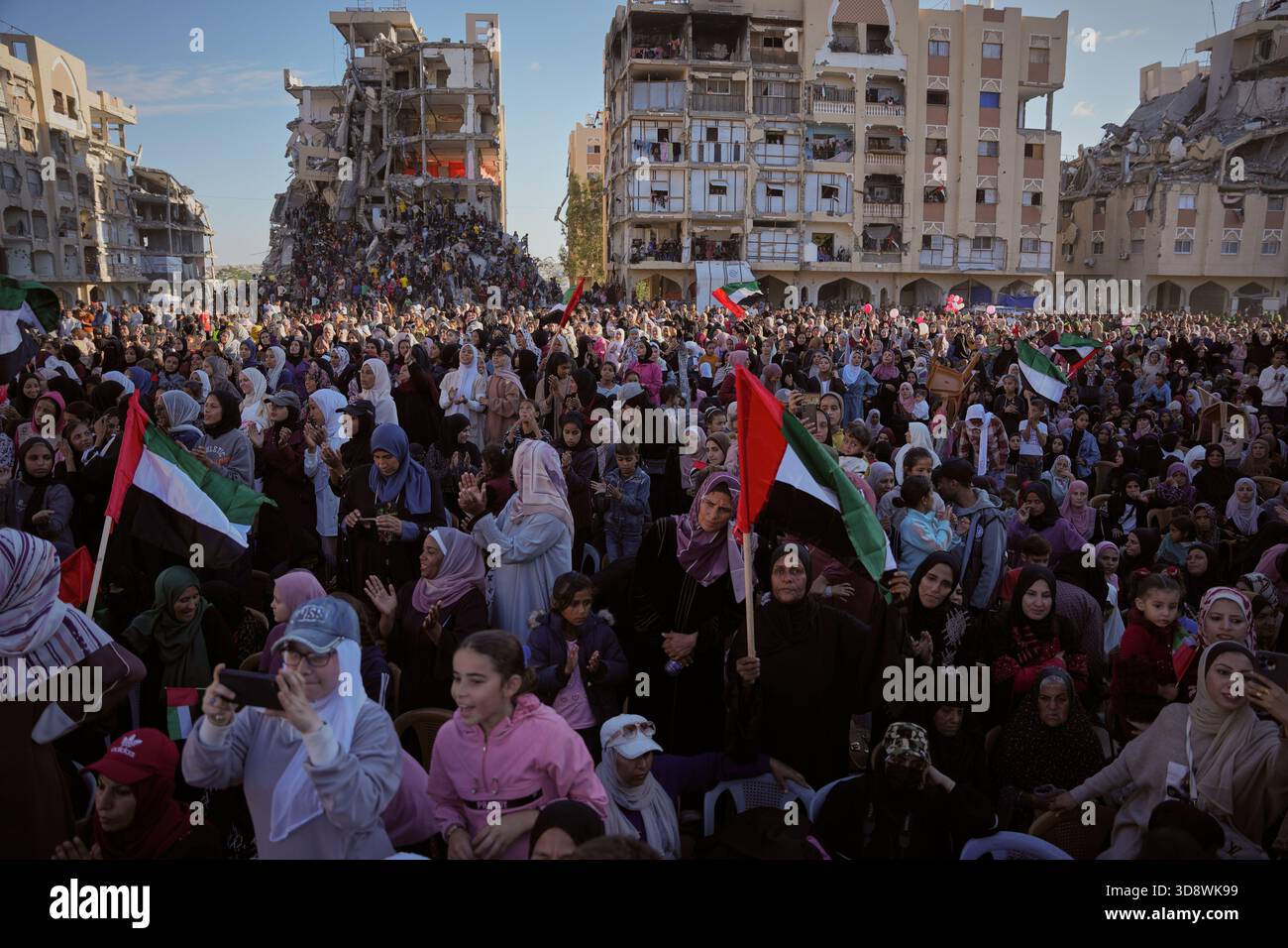 Palestinian watch and celebrate a mass wedding ceremony in Hamad City in Khan Younis, Gaza Strip ...