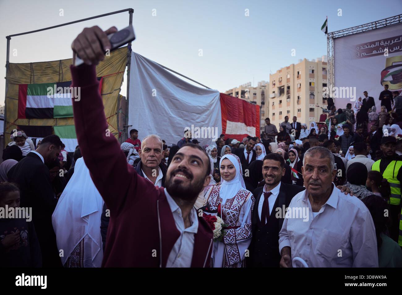 Palestinian couples participate in a mass wedding ceremony at Hamad City in Khan Younis ...
