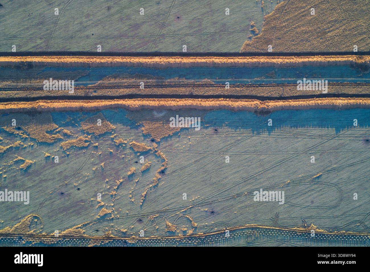 Abstract drone shot capturing parallel anti-tank ditches and a row of ...