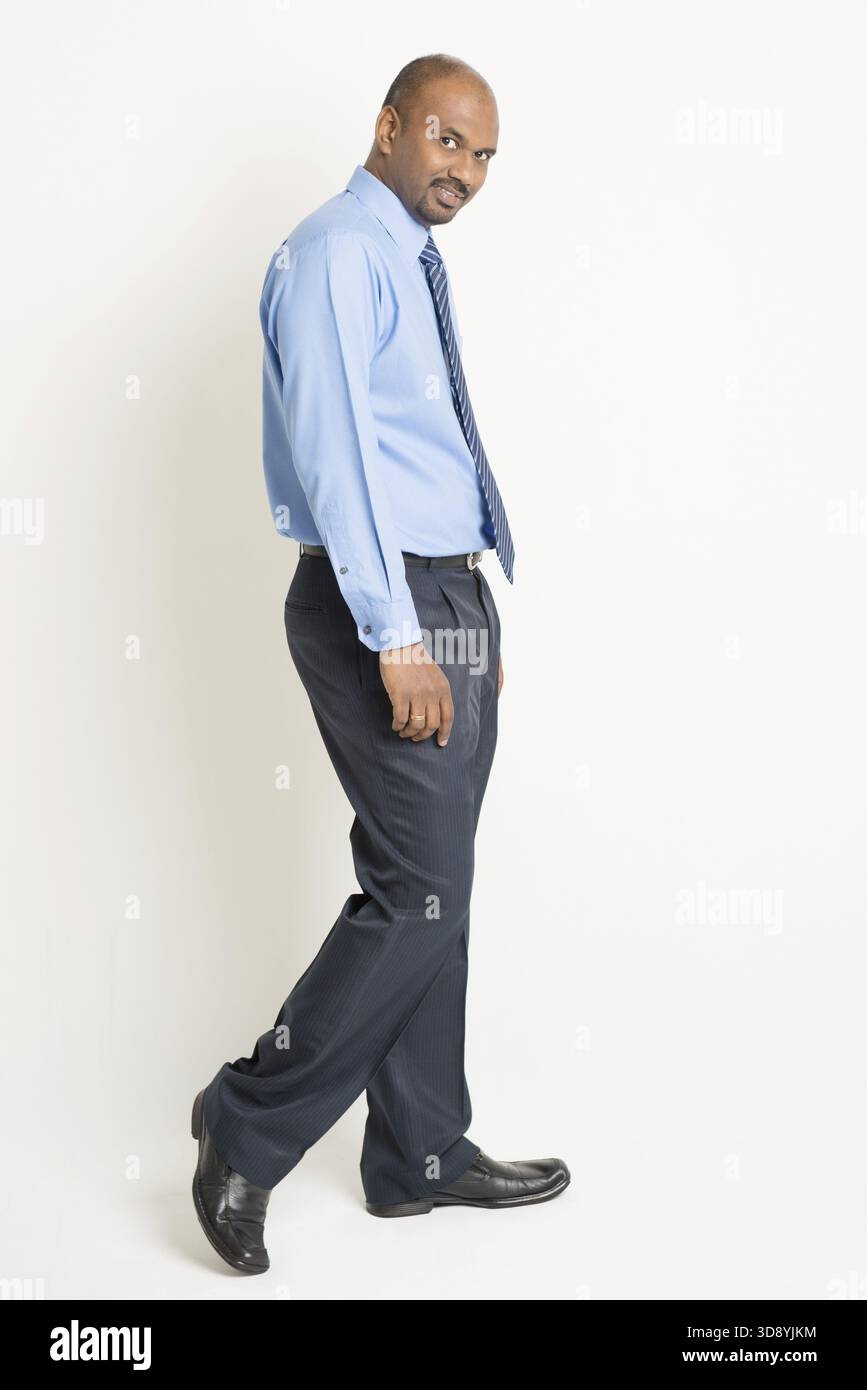Side view Indian businessman walking and turn back head looking at ...