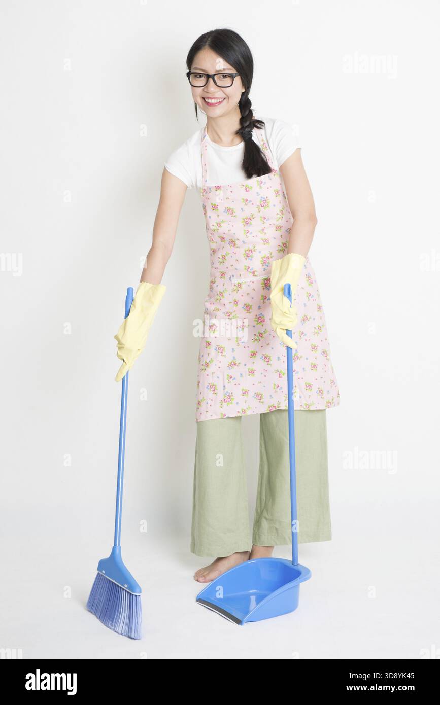 Full length Asian Chinese female housekeeping, sweeping floor with ...