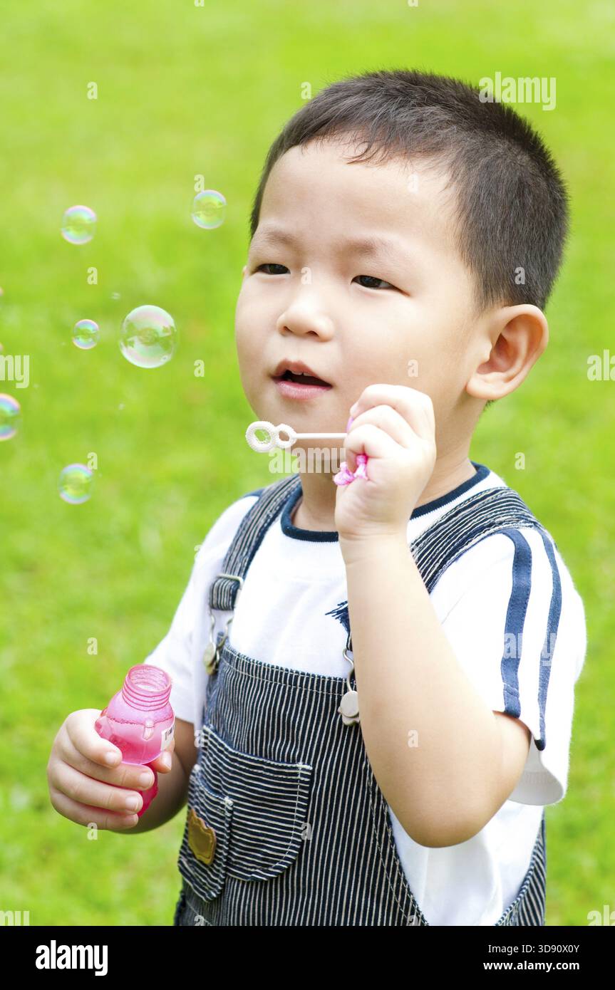 Asian boy blowing bubbles outdoor Stock Photo - Alamy