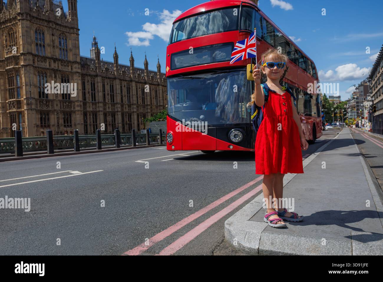 Girl in red with UK flag by classic double-decker bus of London Stock ...