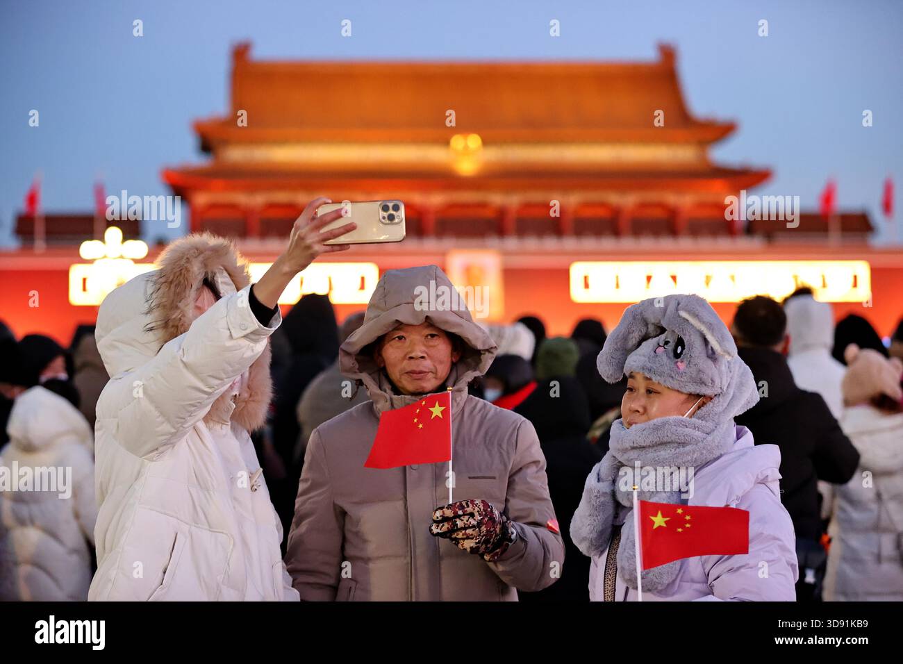 Tourists watch the flag-raising ceremony at Tiananmen Square in Beijing ...