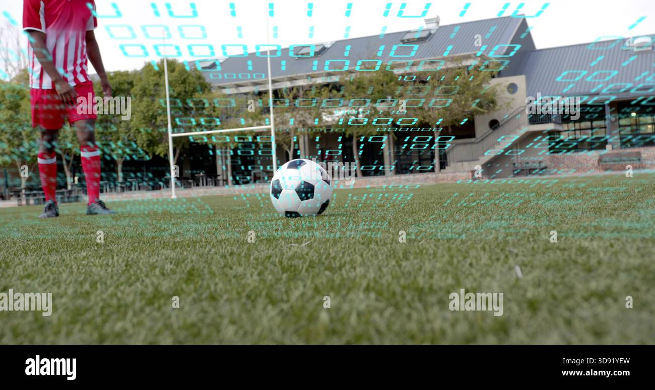 Resting soccer ball centered on turf, player wearing red-striped kit ...