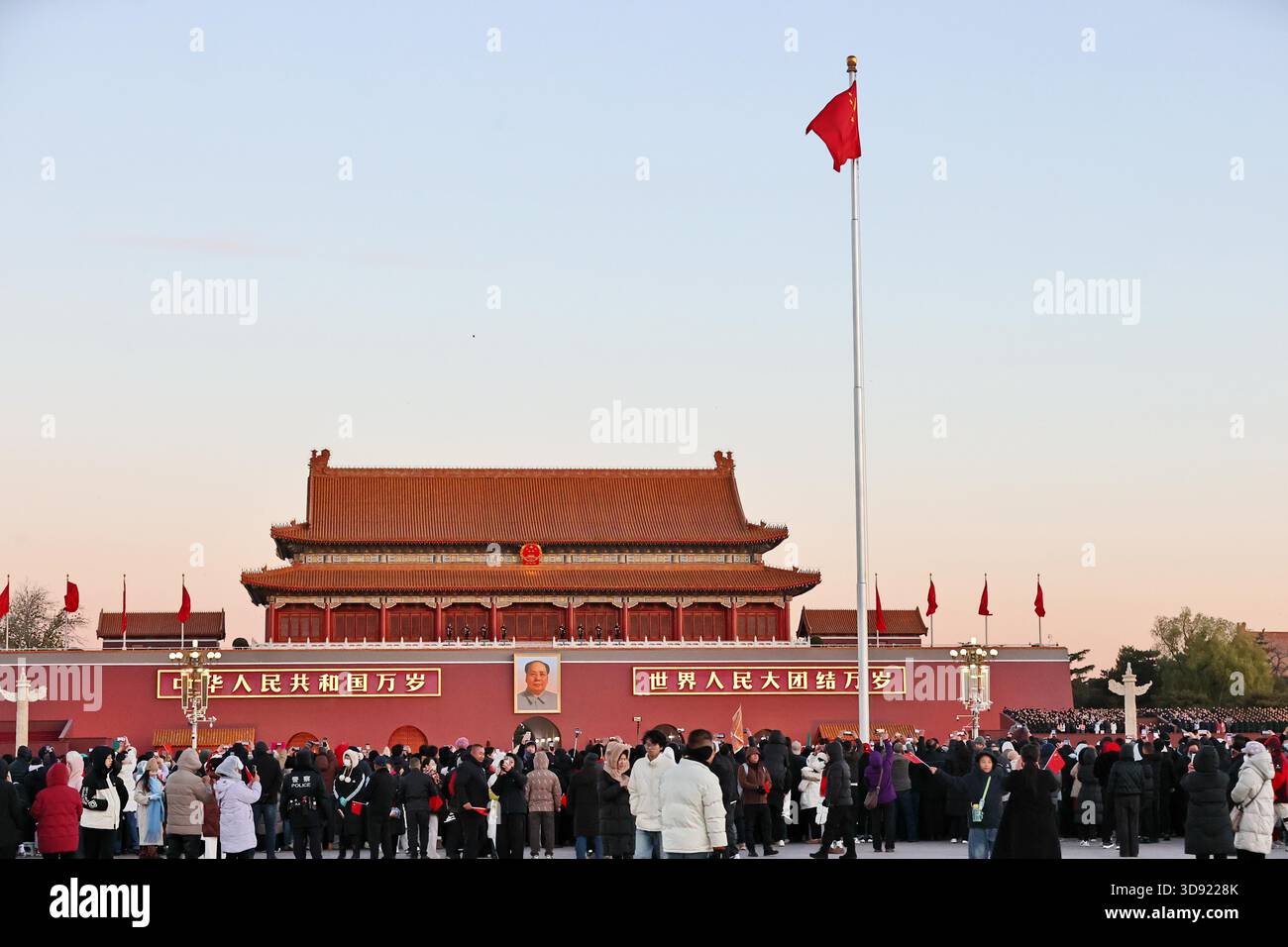 Tourists watch the flag-raising ceremony at Tiananmen Square in Beijing ...