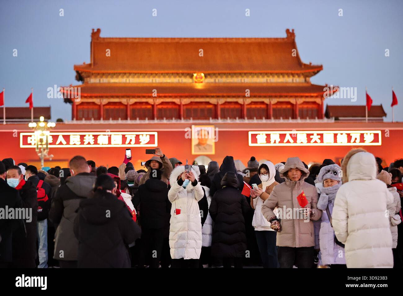 Tourists watch the flag-raising ceremony at Tiananmen Square in Beijing ...