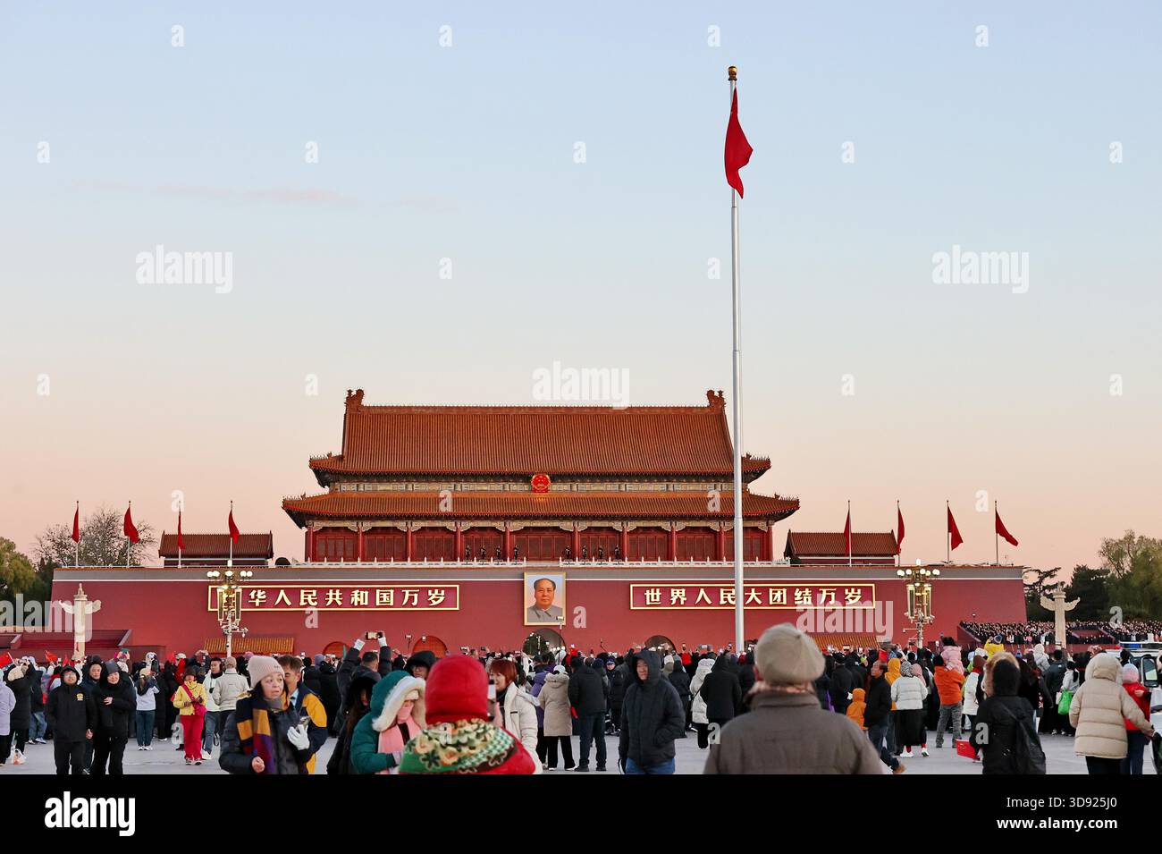 Tourists watch the flag-raising ceremony at Tiananmen Square in Beijing ...