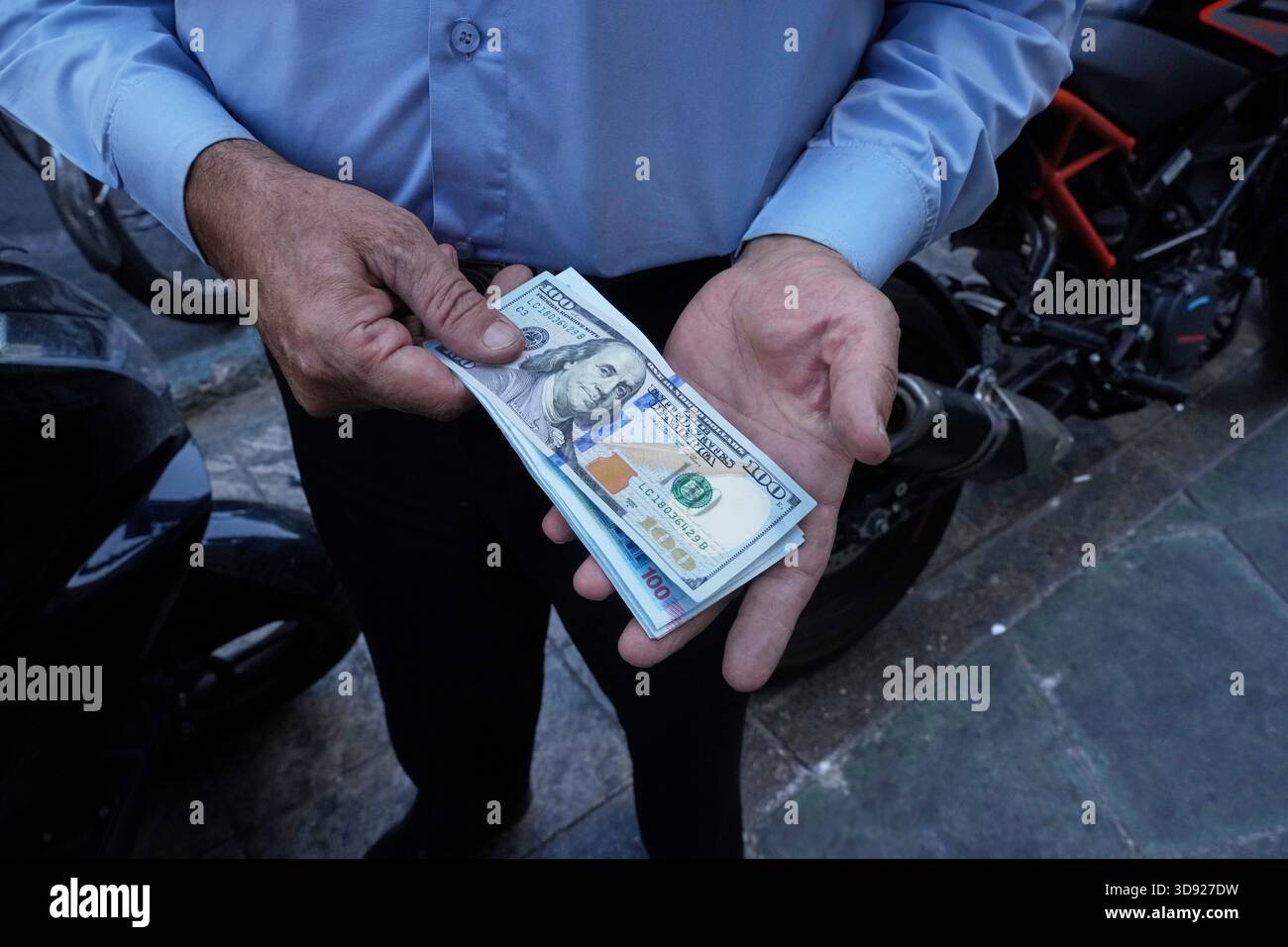 FILE — A street money exchanger poses for a photo without showing his ...