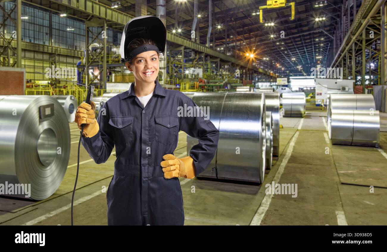 Women factory workers, female welder in a uniform with a welding ...