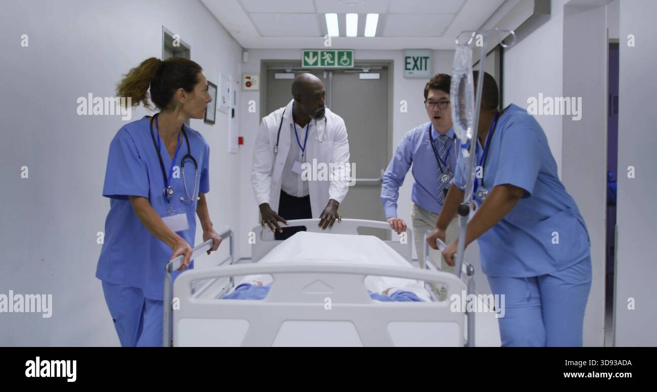 Pushing medical staff in scrubs and coat guiding covered gurney through ...