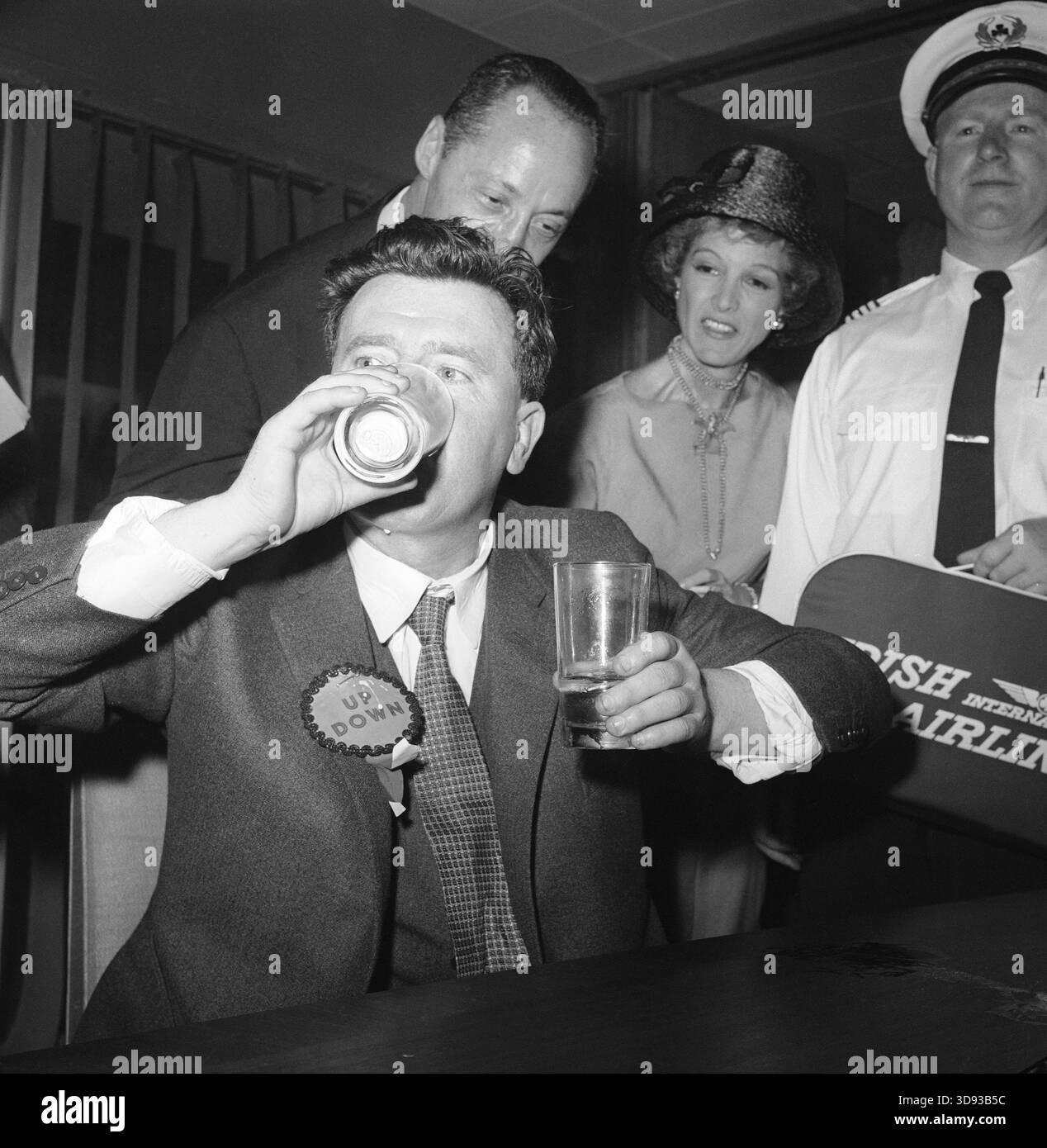 Irish playwright Brendan Behan poses for photographers while drinking a ...