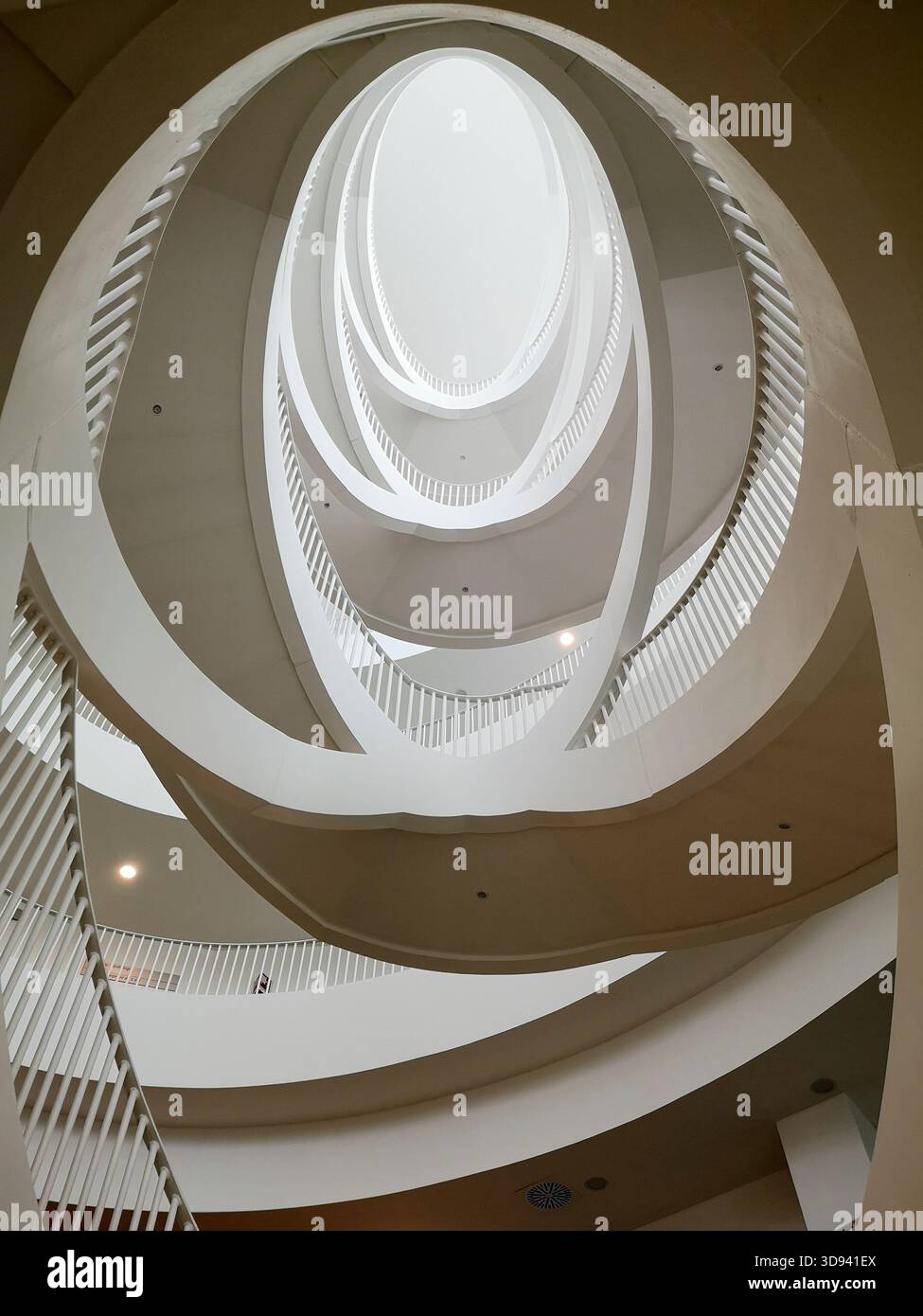 Modern hospital atrium featuring light-filled white balconies curving ...