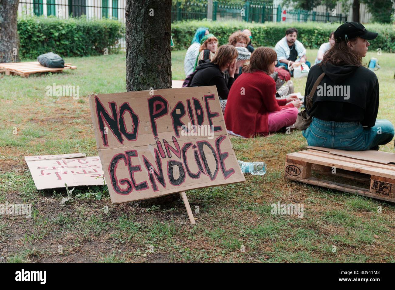 A cardboard sign reading “No Pride in Genocide” rests by a tree as pro ...
