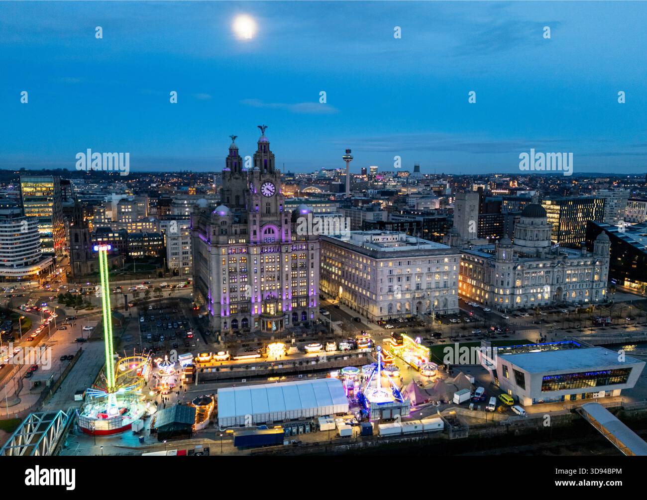 Amusement and fair ground rides captured against the Liverpool skyline ...