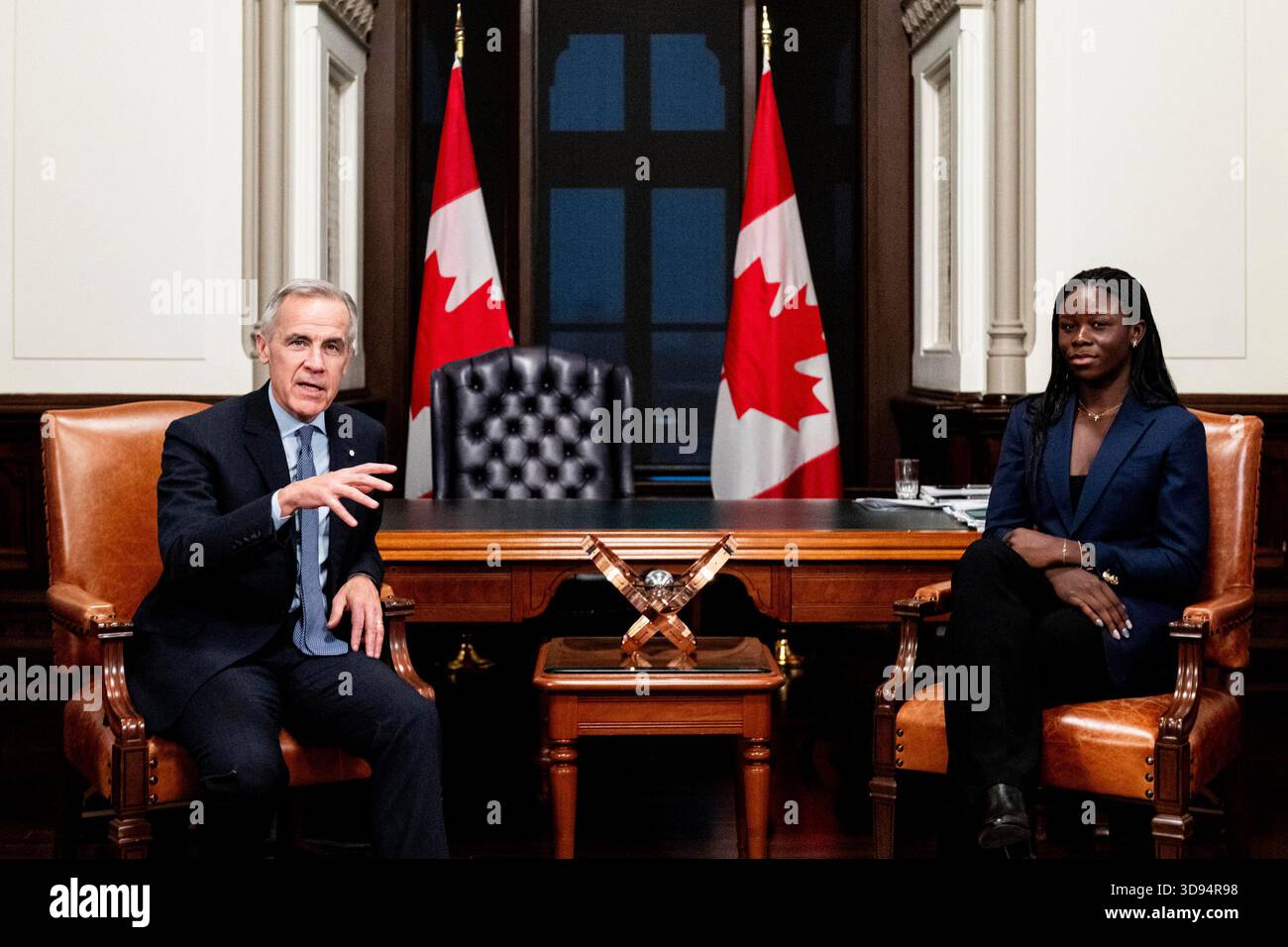 Canada Prime Minister Mark Carney, left, speaks as he meets with tennis ...