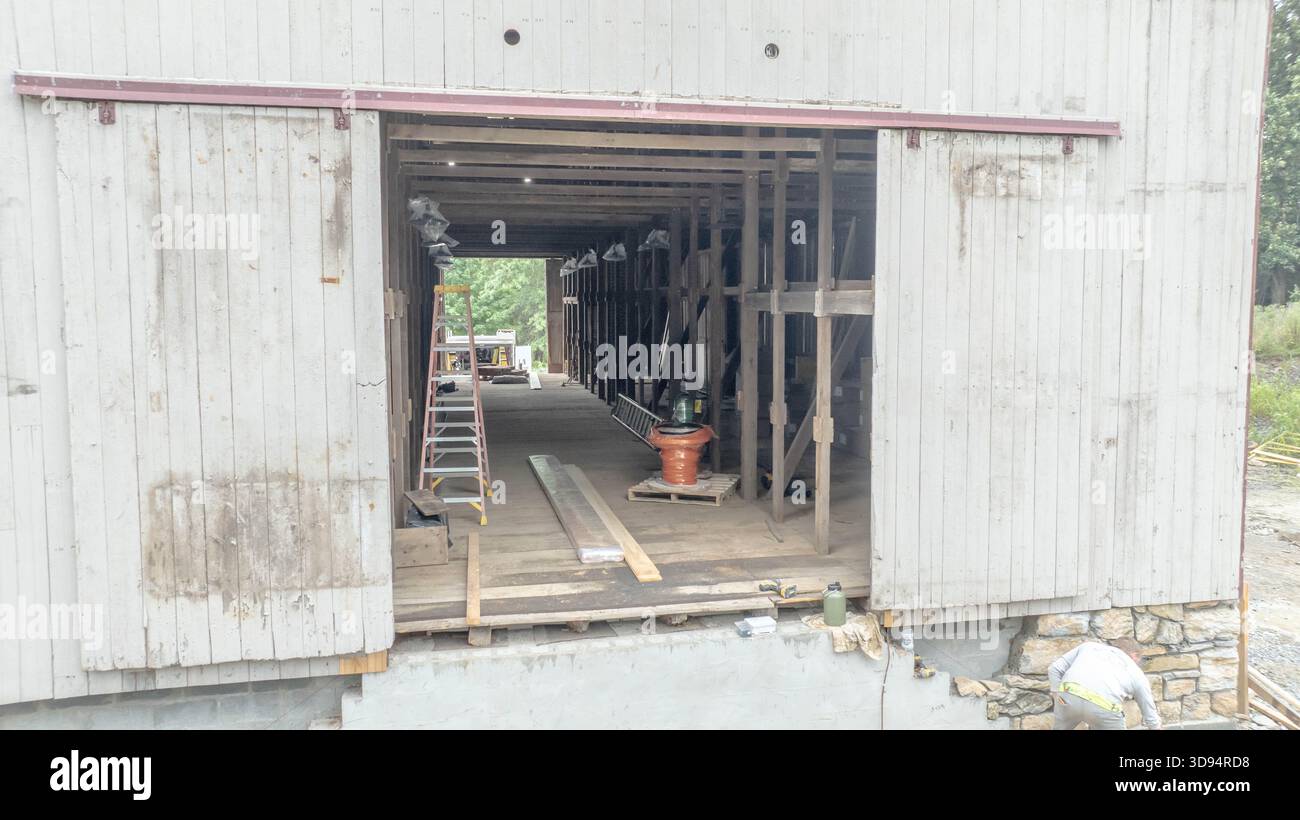Construction workers are renovating a barn, with wooden beams ...