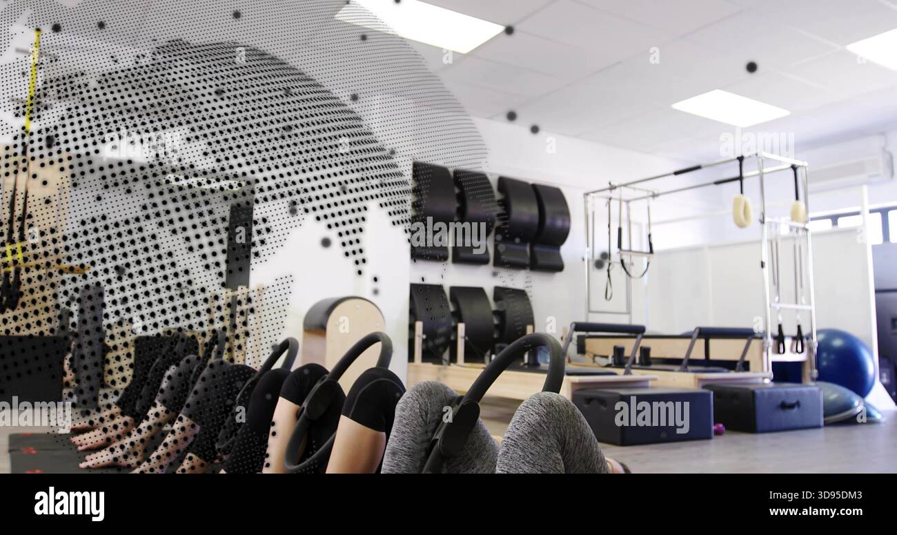 Lying six women wearing leggings holding Pilates rings, raising legs in ...