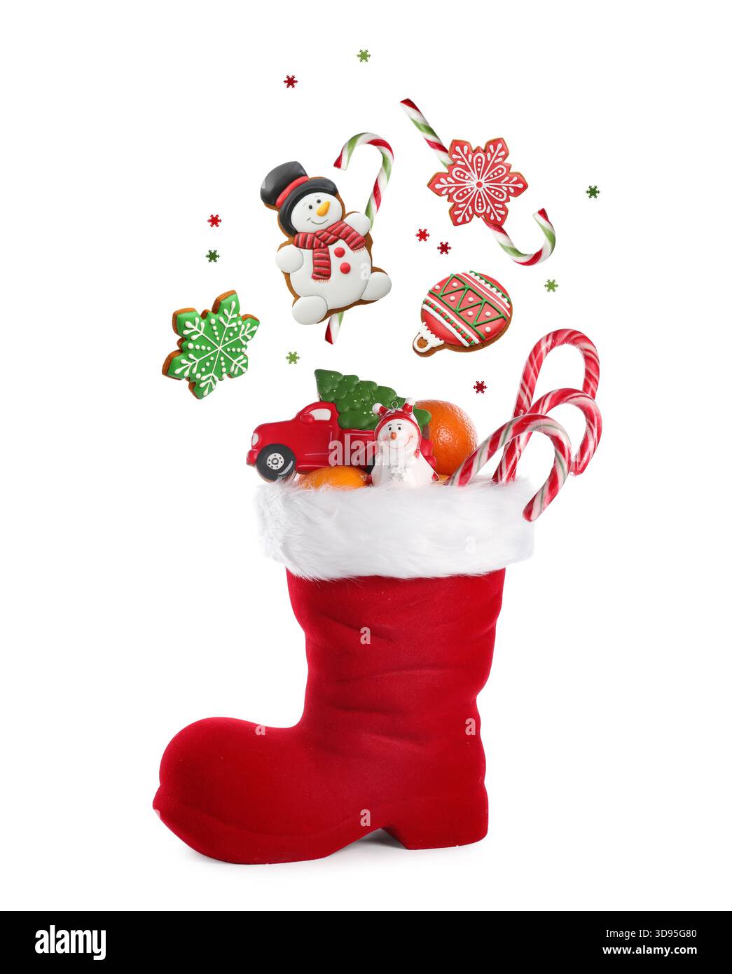 Christmas candy canes and cookies falling into red boot on white ...