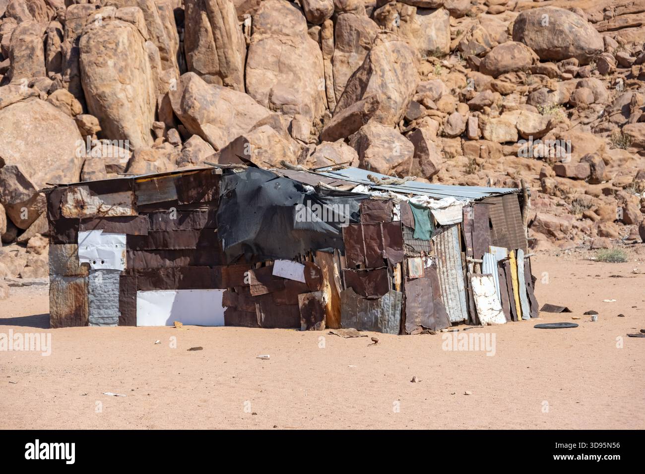 Simple poor huts made of corrugated iron and wood, desert landscape ...