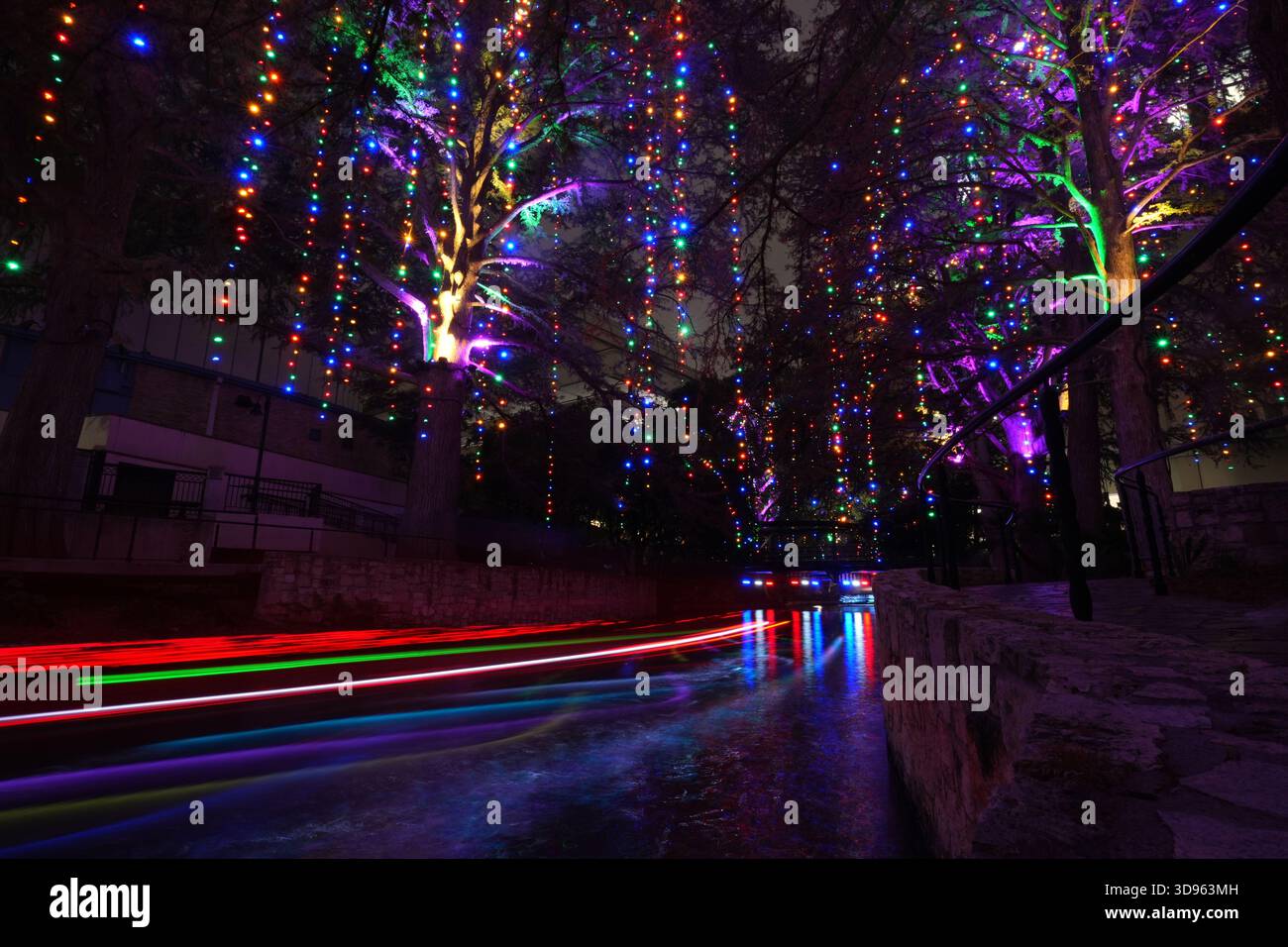 In a timed exposure, a lighted barge moves along the Riverwalk ...