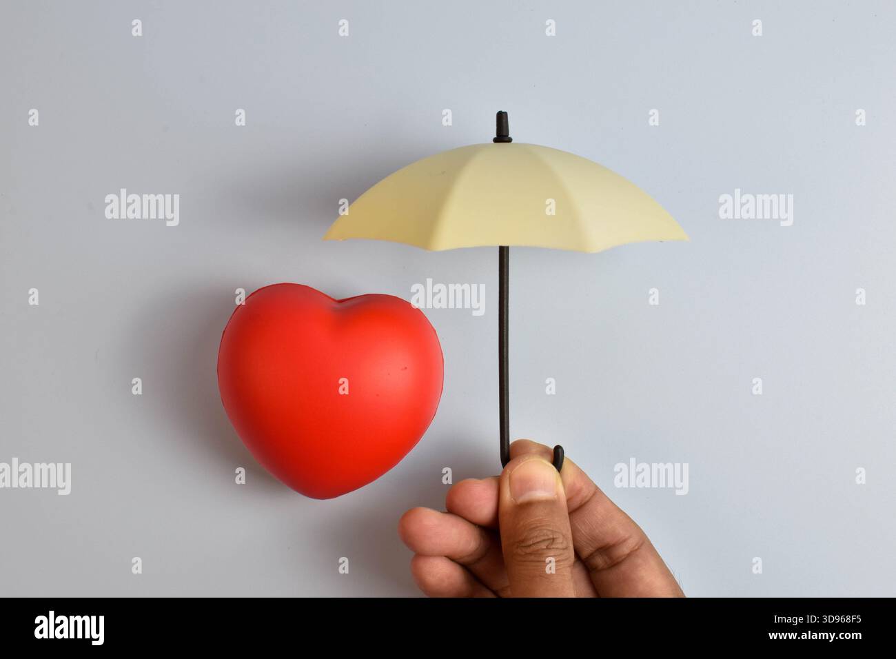 Hand shelters red heart with symbolic gesture representing emotional ...