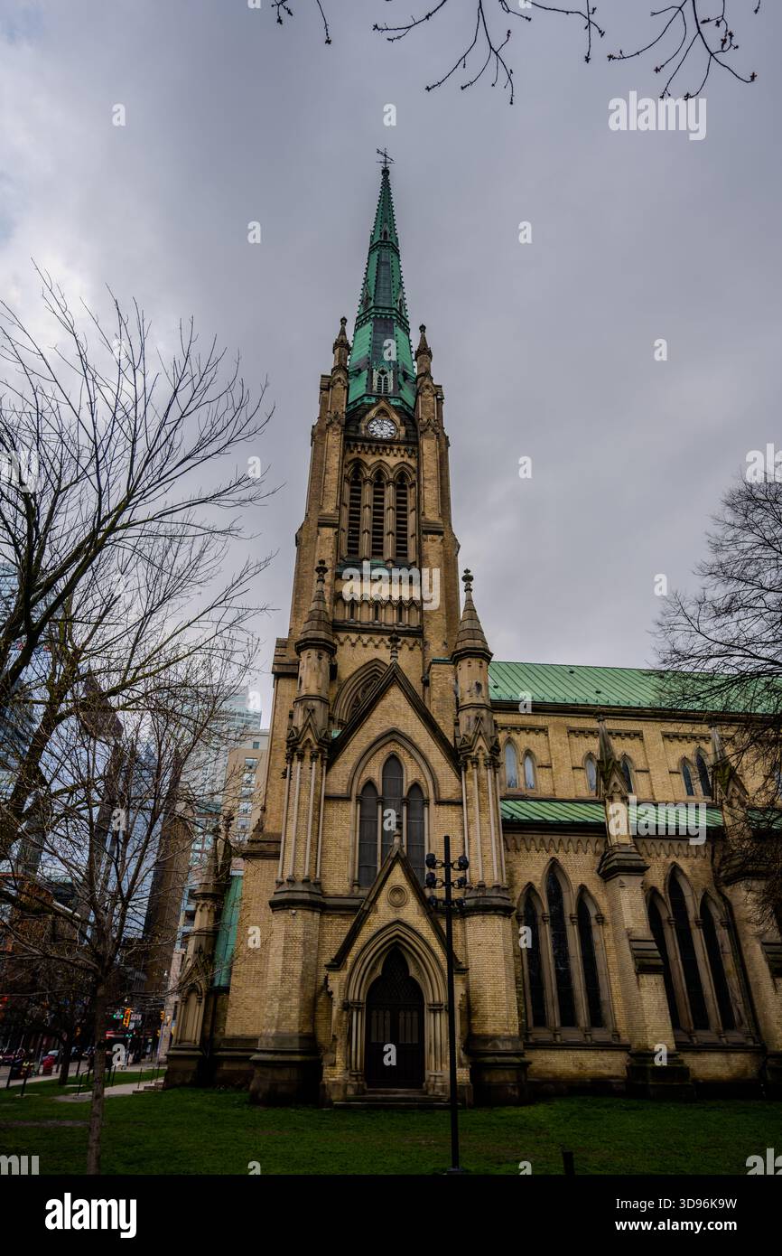 Tall Gothic Revival church with clock tower and green copper roof ...