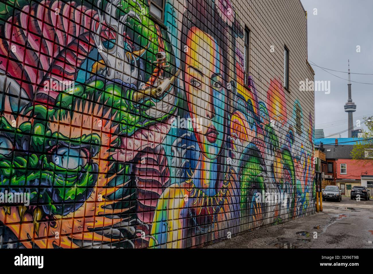 Vibrant street art covers a brick wall in a narrow Toronto alley, with ...