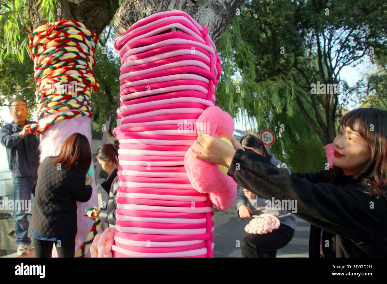 Trees on the street are put on brightly colored "sweaters" for winter ...