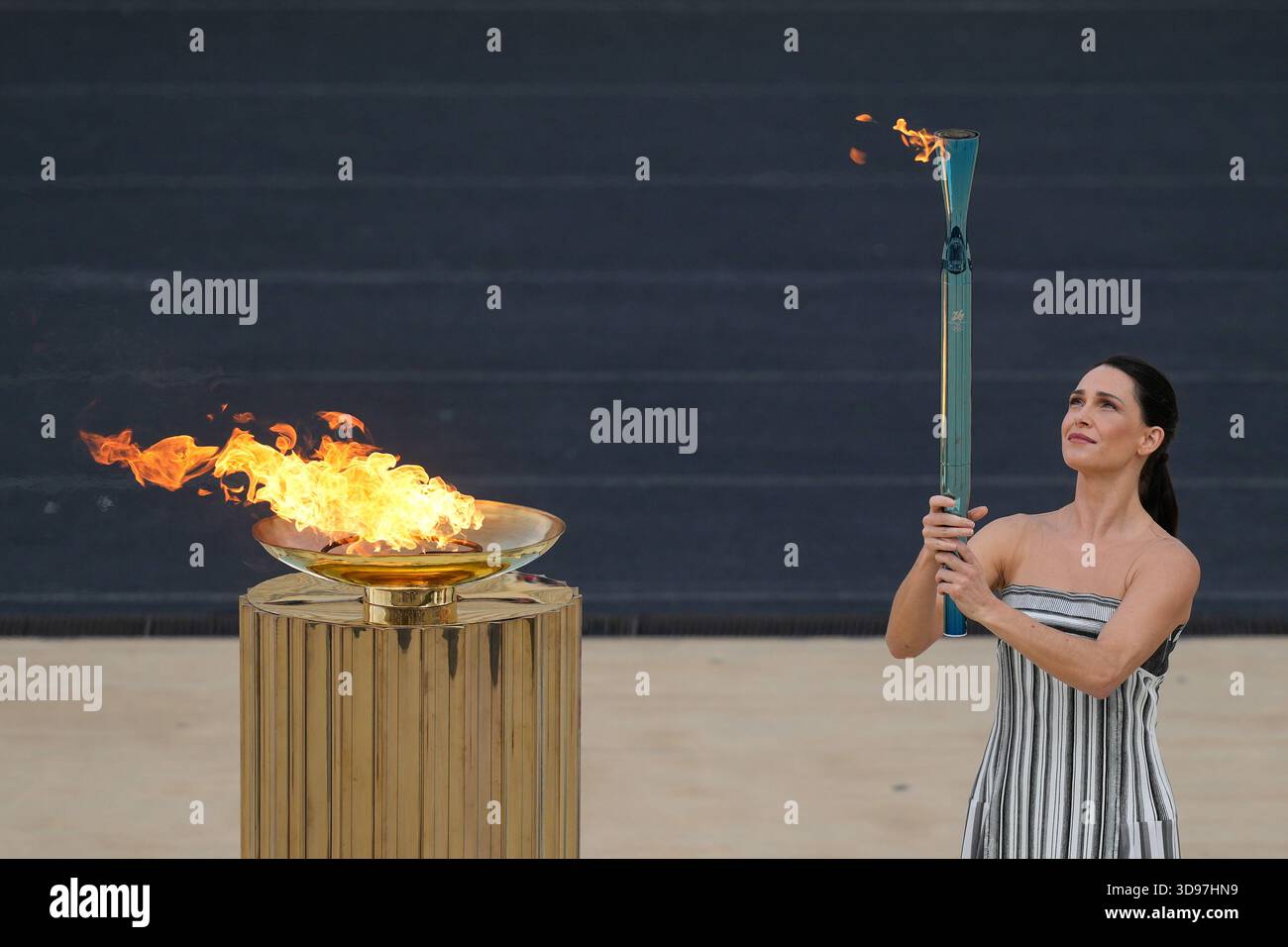 Greek actress Mary Mina, playing the role of High Priestess, lights a ...