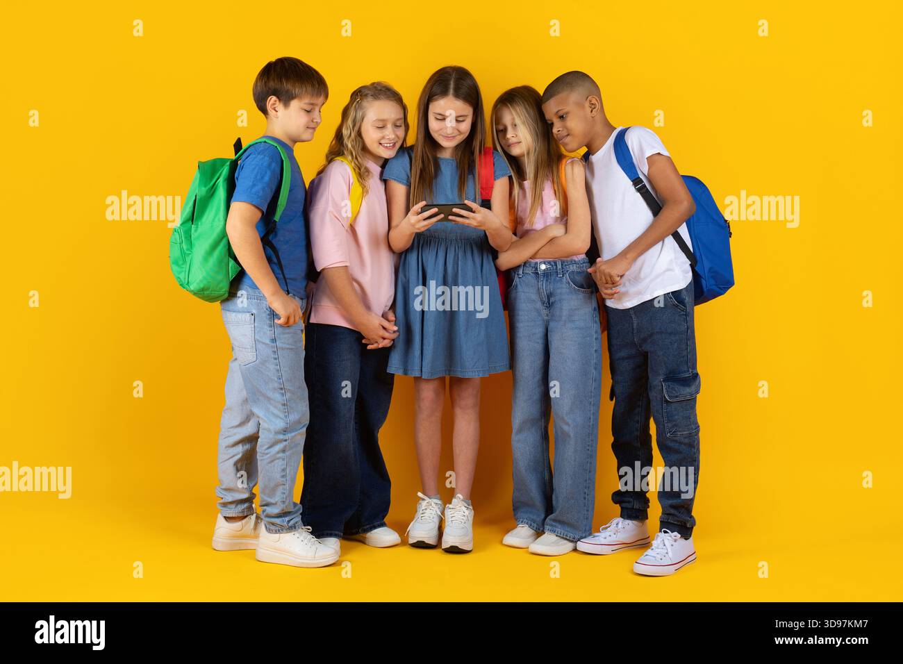 Group of school kids gathered around girl with smartphone in hands ...