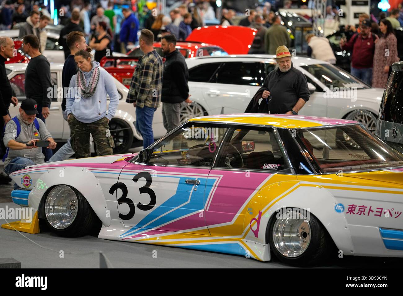 Visitors watch tuned custom cars at the Essen Motor Show in Essen ...