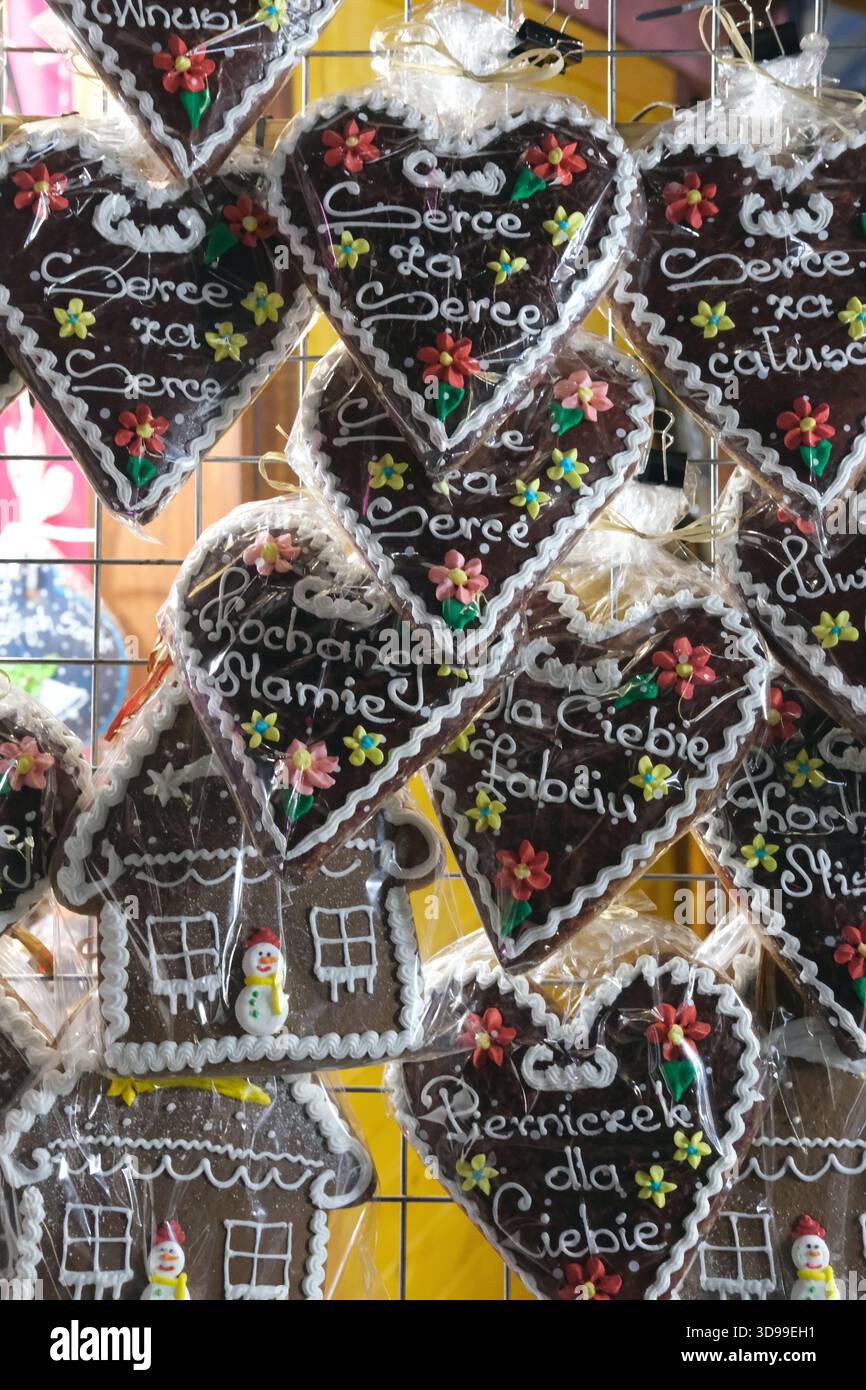 Iced gingerbread hearts wrapped in plastic, hung on metal grid, floral ...