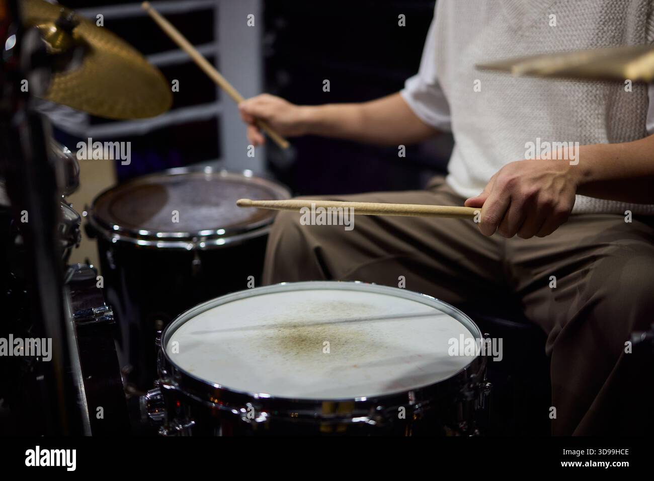 Drummer hands striking snare drum with sticks, captured midperformance ...