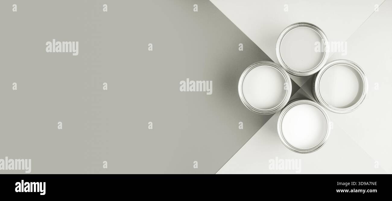 Four open paint tins with subtle shades of grey paint, arranged on a ...