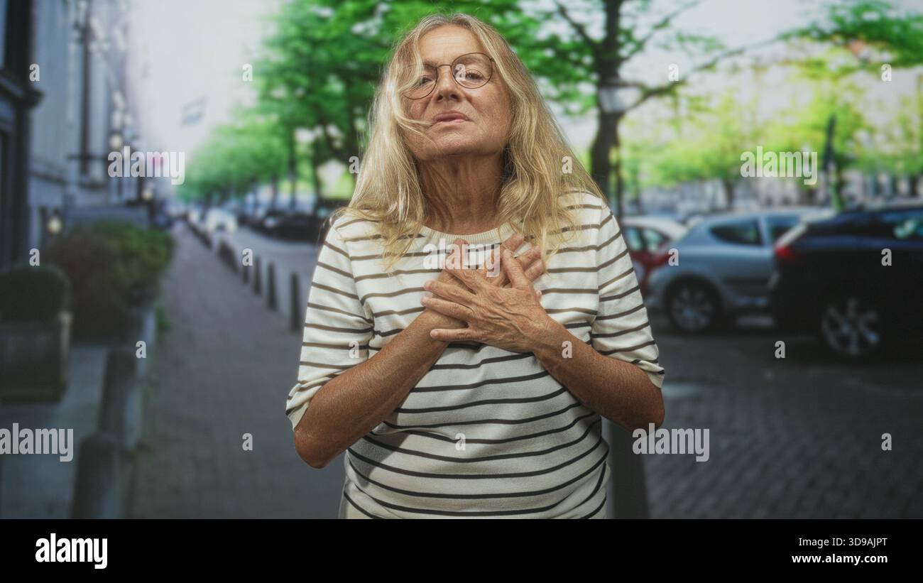 Senior woman clutching chest with hands over heart on street, possible ...