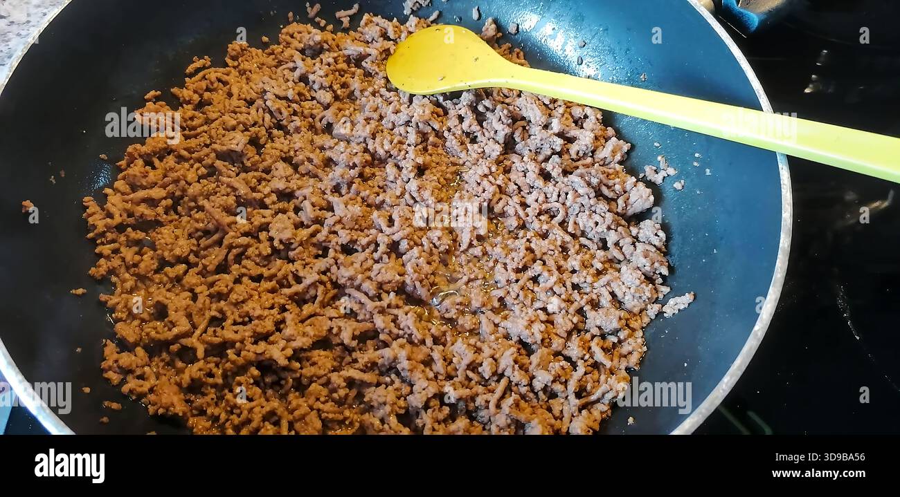 Ground meat sizzles in a pan, browning evenly during cooking Stock ...