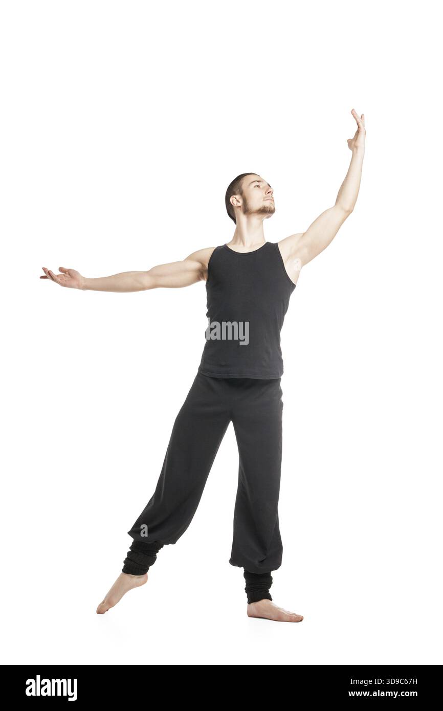 Portrait of male ballet dancer in black posing with arm raised.Isolated ...