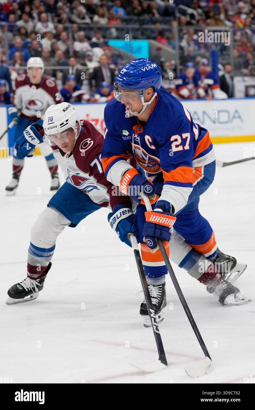 Colorado Avalanche's Sam Malinski, left, tries to get the puck from New ...