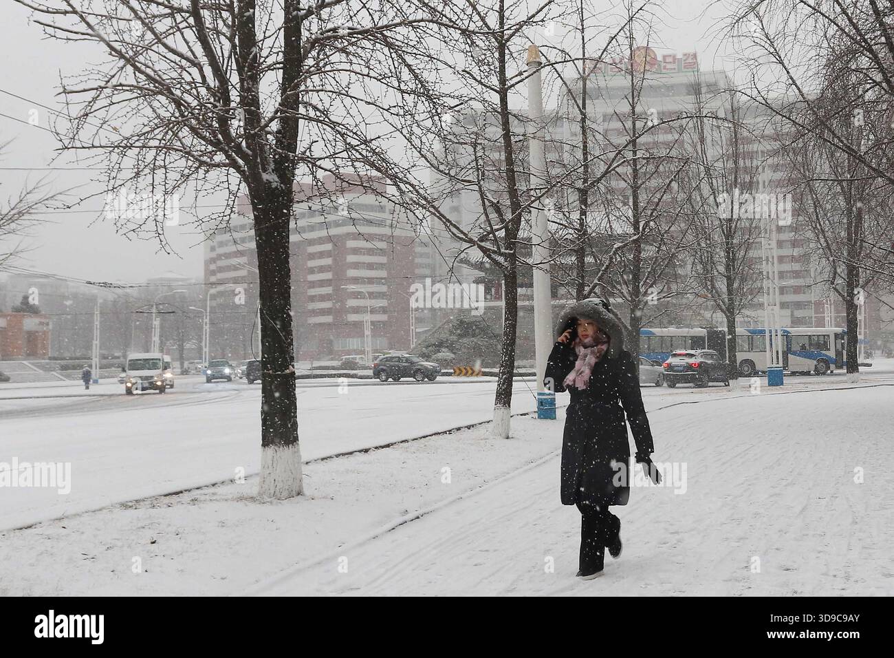 People walk on a snow-covered street of the Pothonggang District ...