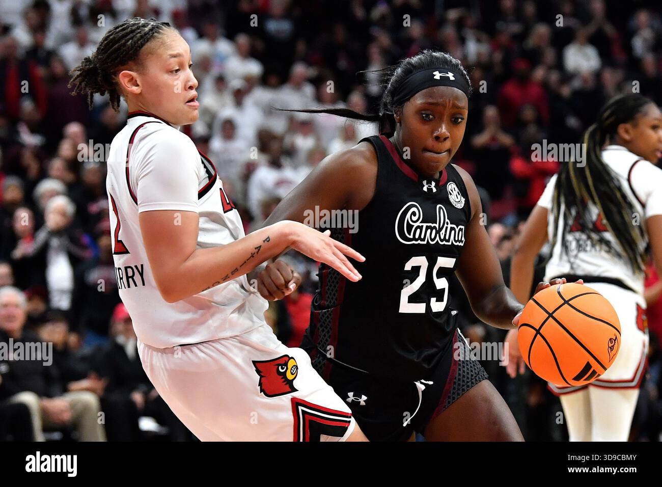 South Carolina guard Raven Johnson (25) drives past Louisville guard ...