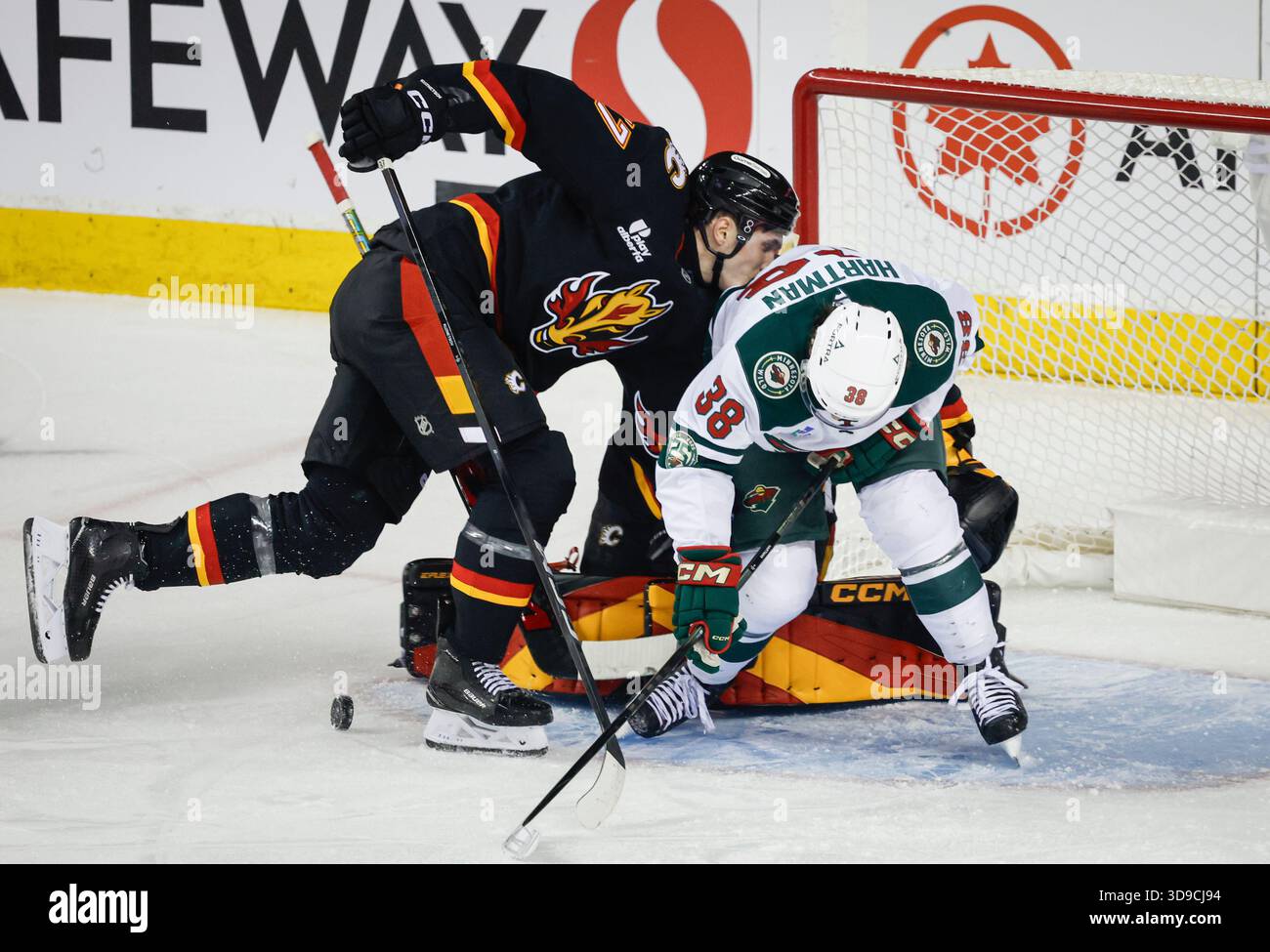 Minnesota Wild's Ryan Hartman, right, is checked by Calgary Flames' Yan ...
