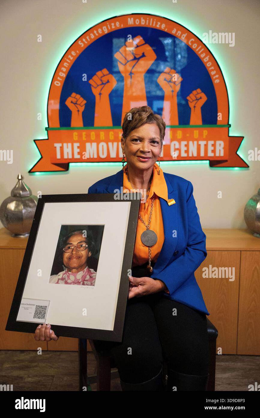Deborah Scott, CEO of Georgia Stand-Up, holds a portrait of civil ...