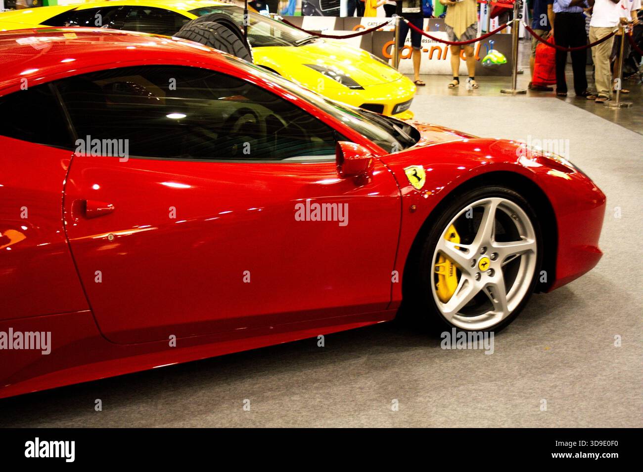 A vibrant red Ferrari sports car gleams under the lights at an indoor ...