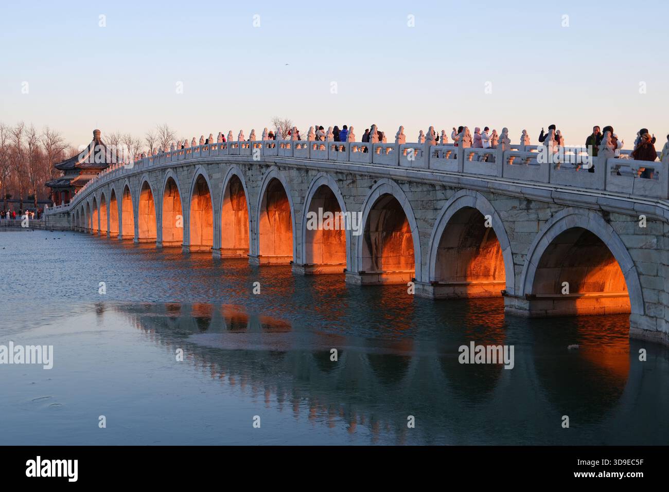 Sunset rays illuminate the Seventeen-Arch Bridge at the Summer Palace ...
