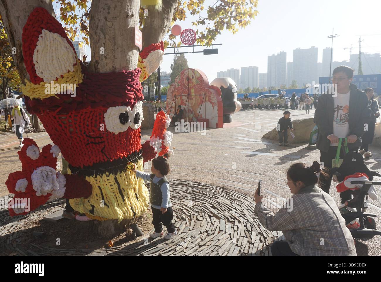 Trees on the street are put on brightly colored "sweaters" for winter ...