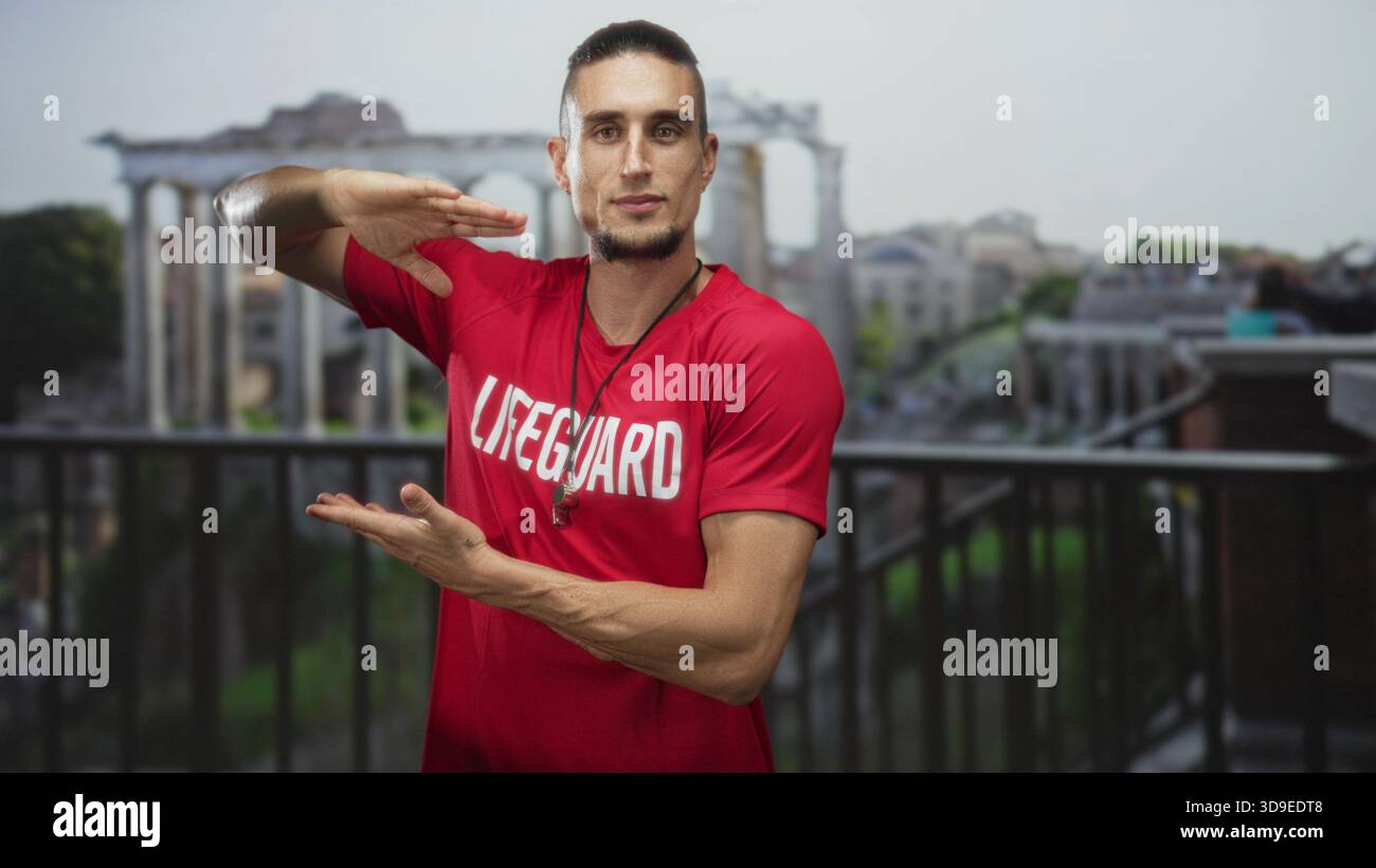 Lifeguard man in red shirt frames empty space with hands, showing ...
