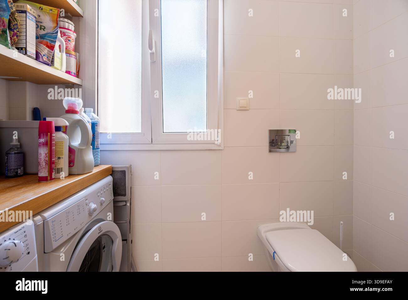 Compact utility space featuring washing machine, detergent storage ...
