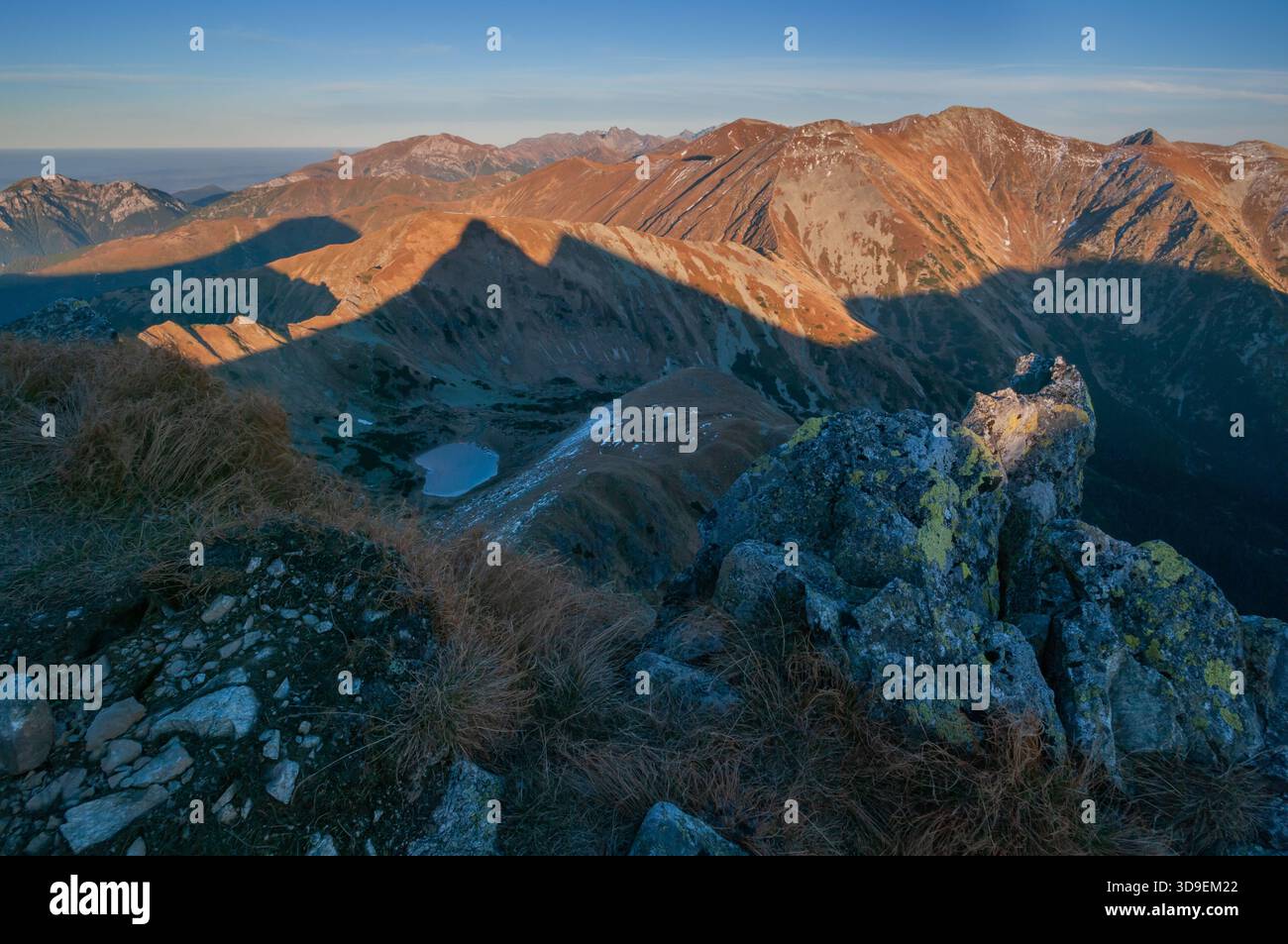 Aerial view of dramatic shadows cast across rugged mountain peaks, with ...